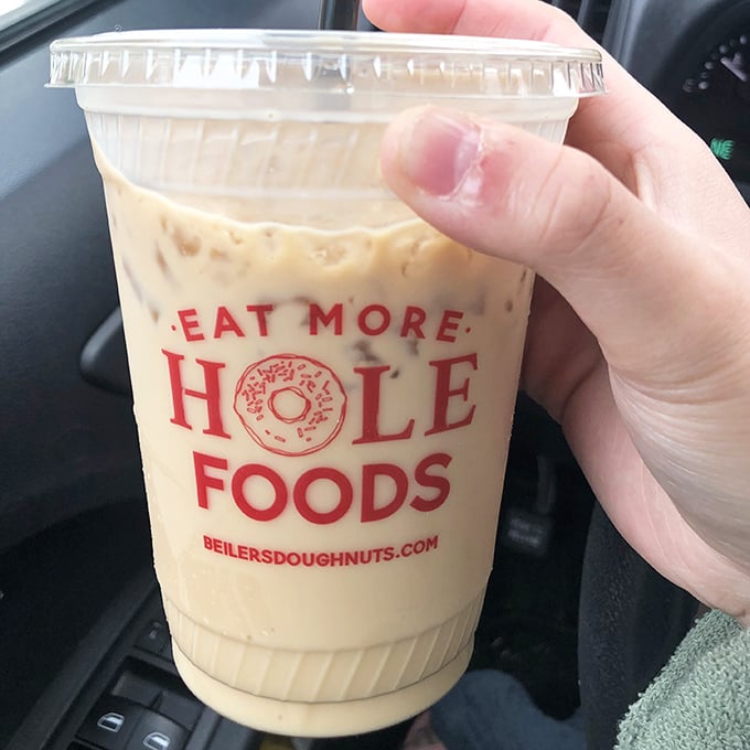 "Eat More Hole Foods"—the cup says it all. This iced coffee isn't just a beverage; it's the perfect doughnut wingman.