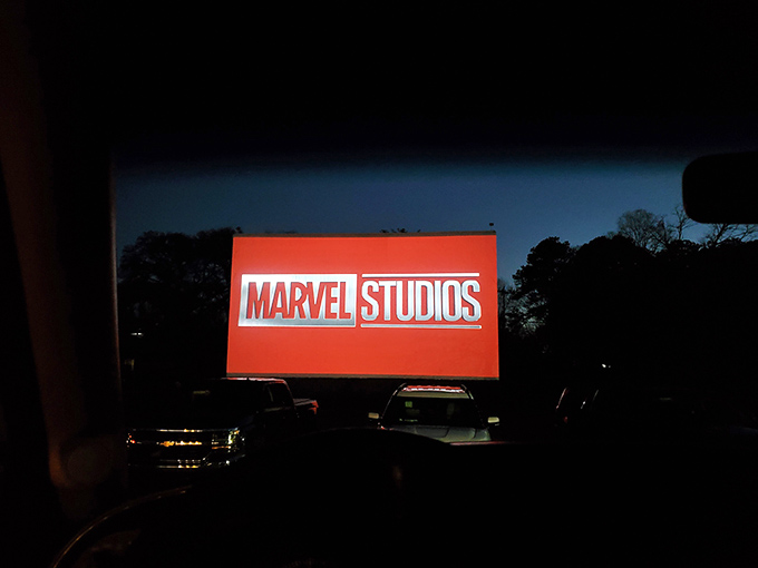 The Marvel logo illuminates dozens of windshields, turning ordinary vehicles into front-row seats at cinema's most democratic venue.