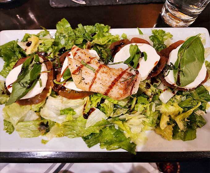 Fresh greens, heirloom tomatoes, and mozzarella create the kind of salad that makes you temporarily forget you came for steak. But only temporarily.