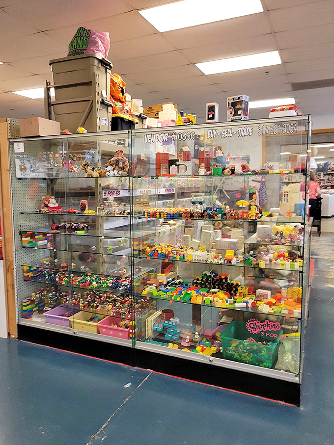 Behind glass, a miniature universe of collectible toys awaits. From Shopkins to vintage figurines, childhood memories are preserved in this colorful display case.