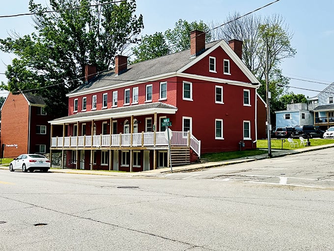 The red Lehoullier Building stands proud, its wraparound porch suggesting a time when businesses had personality beyond their logo design.