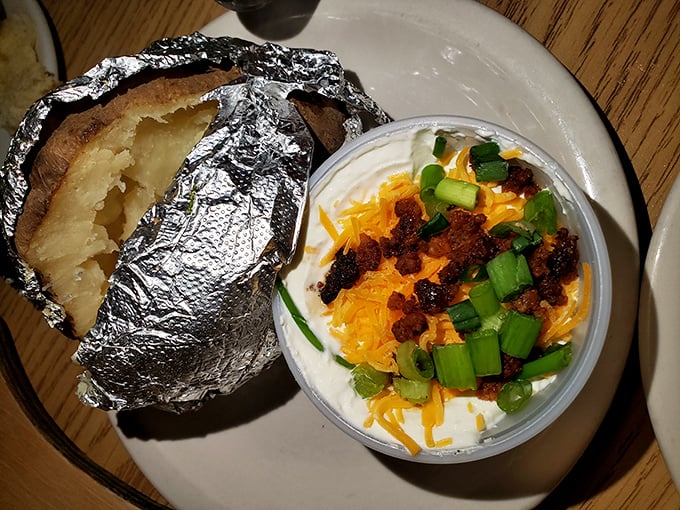 A foil-wrapped spud hiding buttery treasures inside, topped with enough fixings to make Idaho jealous.