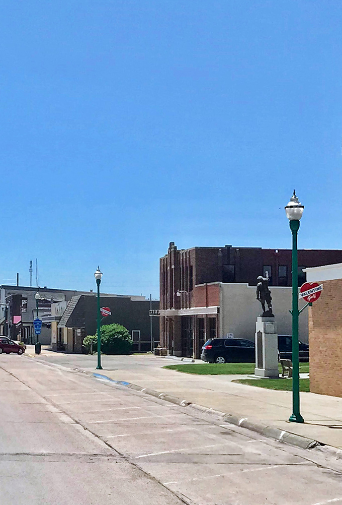 A statue stands sentinel on Main Street, honoring those who shaped this prairie town while vintage lampposts add a touch of timeless elegance.