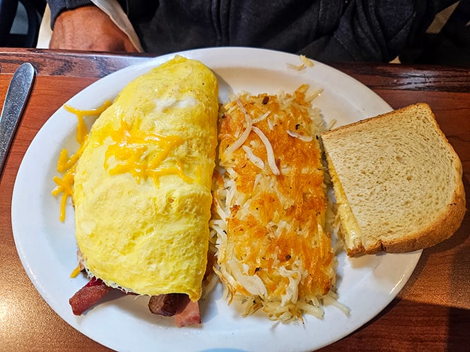 This omelet doesn't just contain ingredients; it embraces them in a fluffy yellow hug alongside hash browns that achieved the perfect crisp-to-tender ratio.