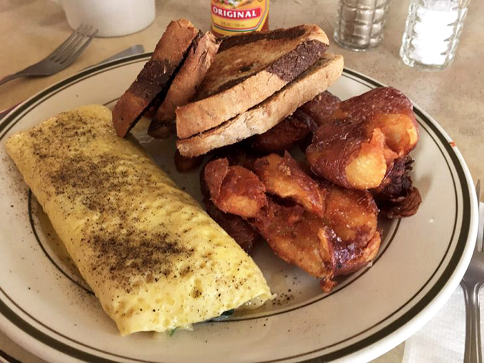 An omelet that whispers, "Someone in this kitchen actually cares about eggs." Paired with potatoes that had a higher calling than mere side dish.