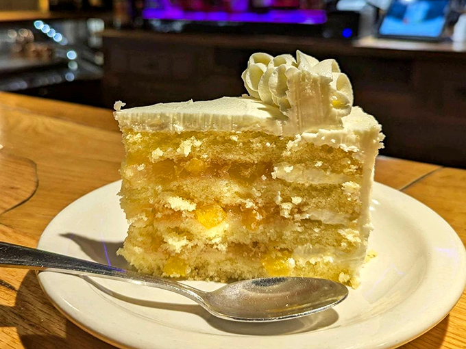 A slice of cake that makes you understand why people used to fight duels over dessert&mdash;layers of sunshine-bright peach nestled between clouds of vanilla frosting.