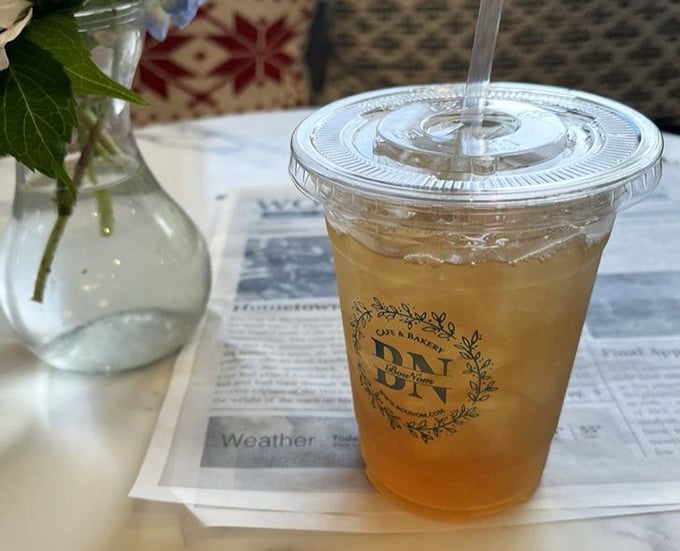 Their peach ginger iced tea sits elegantly on newsprint—refreshment with a side of sophistication.
