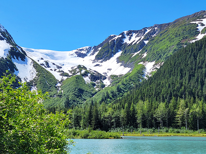 Turquoise waters meet emerald forests beneath snow-capped peaks &ndash; nature showing off all her best colors in one breathtaking Girdwood vista.