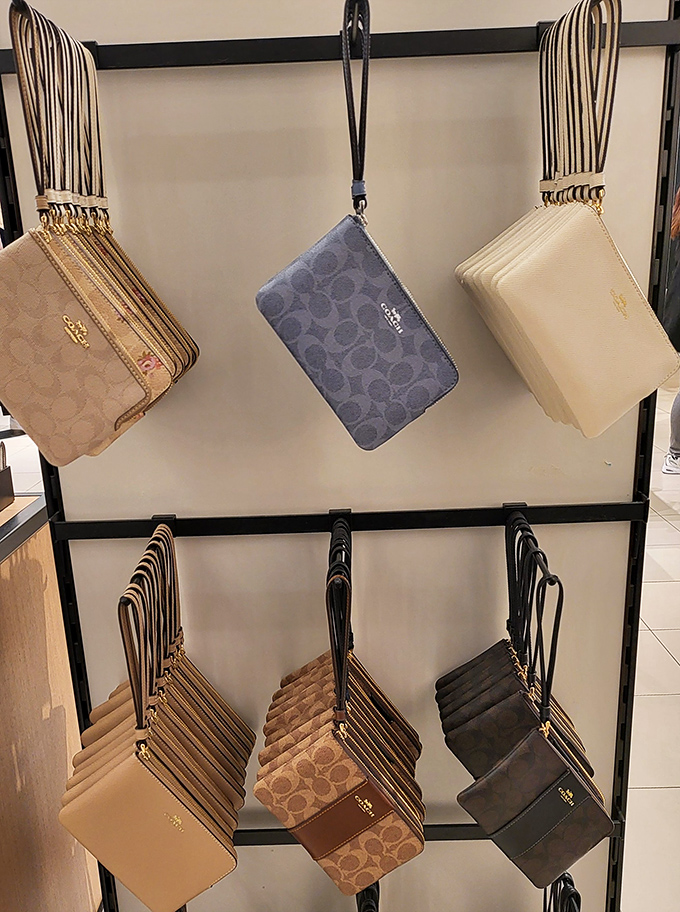 Coach wristlets hanging like perfectly ripened fruit, ready to be plucked by savvy shoppers who know good things come in small packages.