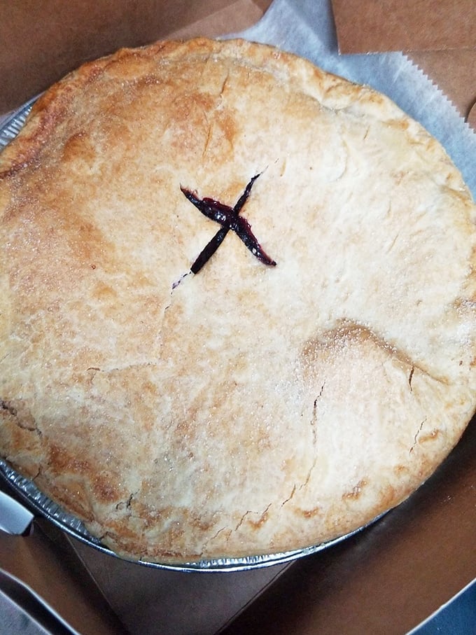 A classic double-crust pie with that telltale "X" marking the spot where fruit treasures hide. The berry filling peeking through promises sweet-tart perfection.