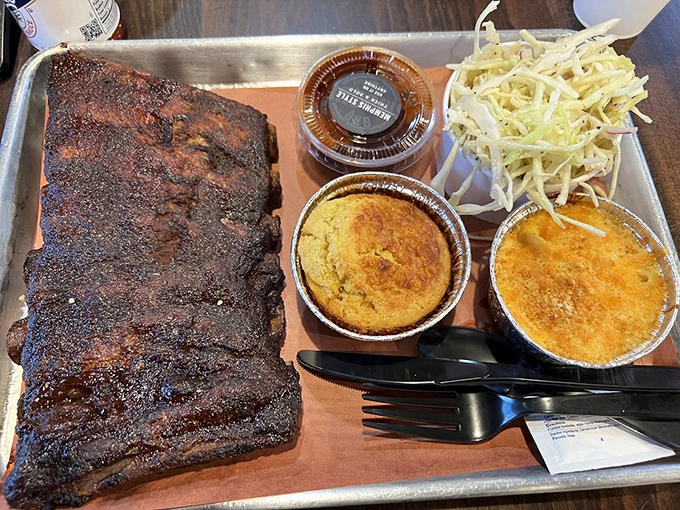 A barbecue platter that makes vegetarians question their life choices. The cornbread and slaw provide moral support for the main attraction.