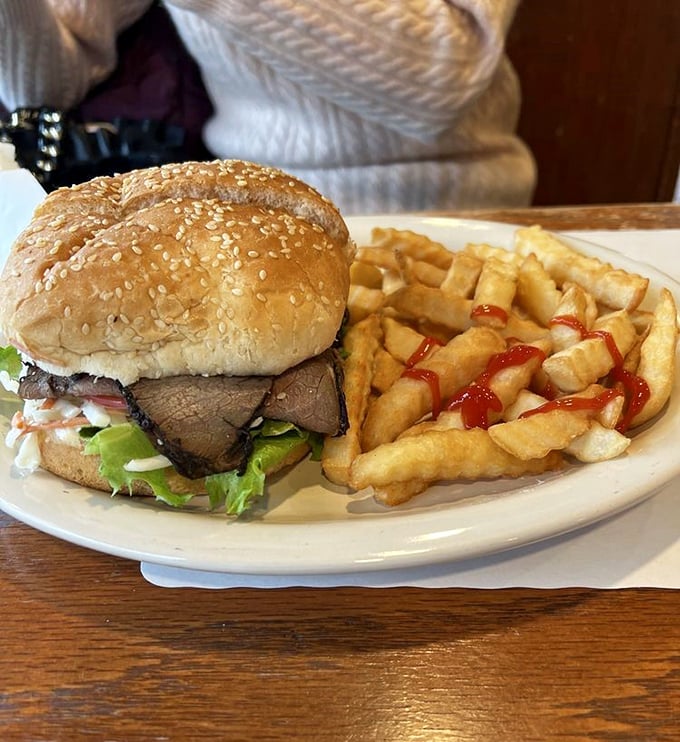 A sandwich that means business. Tender roast beef nestled between a sesame-studded bun with crispy fries standing guard.