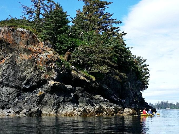 Nature's fortress walls &ndash; ancient rock formations standing guard over Kachemak's waters while kayakers seek passage through the kingdom.