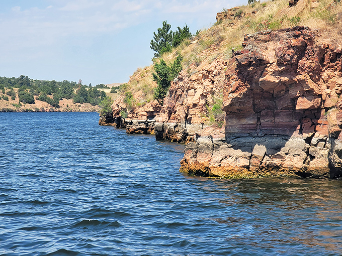 These layered red cliffs tell geological stories older than Betty White, while creating the perfect dramatic backdrop for your fishing selfies.