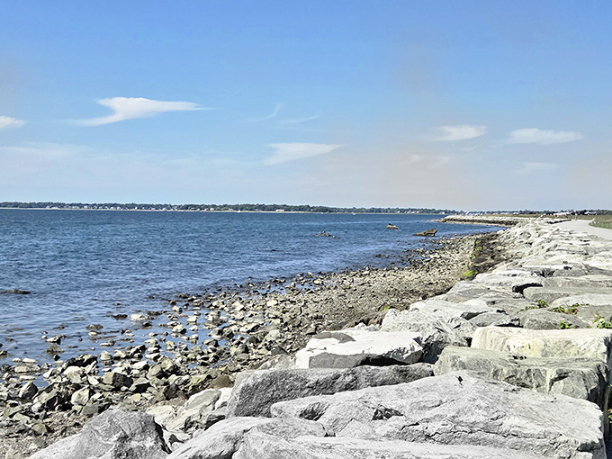The rocky shoreline offers a rugged contrast to smooth lawns above. These ancient stones have witnessed centuries of tides and human history.
