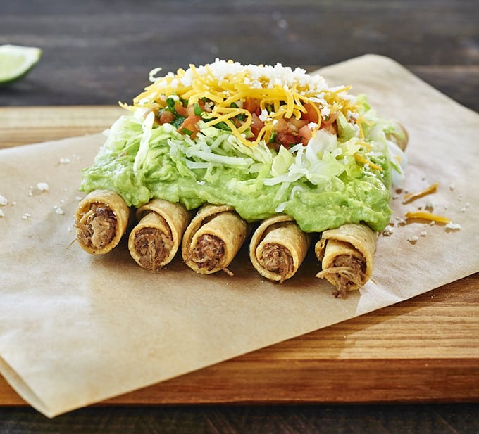 Rolled tacos standing at attention under a blanket of guacamole. Like tiny, crispy soldiers guarding the gates to flavor town.