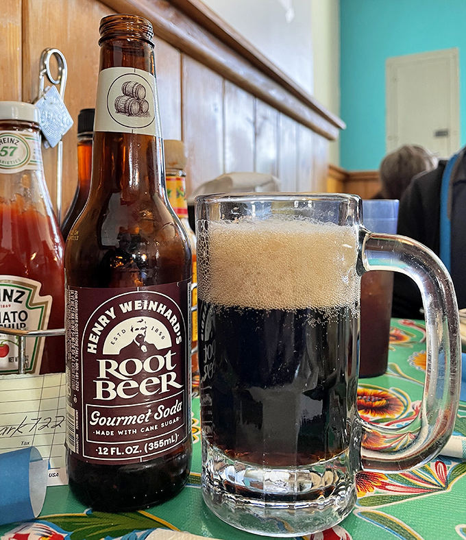 Root beer served in a proper mug, because some traditions deserve respect. The condensation on the glass practically whispers "summer afternoon."