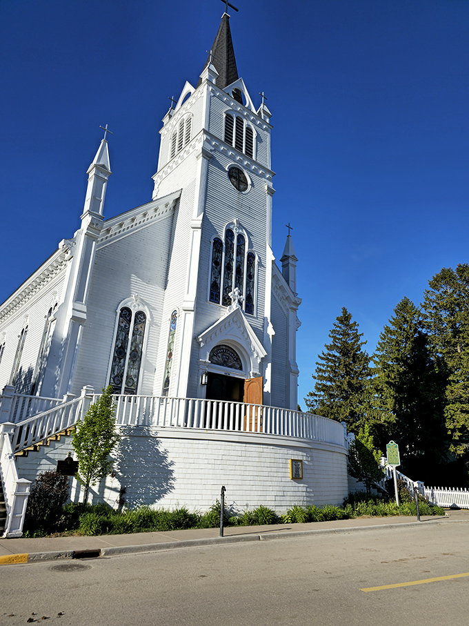 Sainte Anne's Catholic Church reaches skyward with its brilliant white steeple, a spiritual landmark visible to visitors approaching from the water.