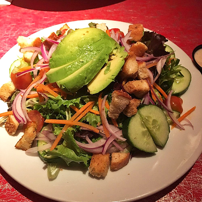 Even the salads here mean business – fresh greens, vibrant veggies, and creamy avocado proving that "eating light" doesn't mean sacrificing satisfaction.