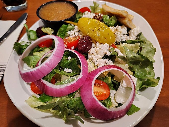 A Greek salad that actually looks like it's trying. Those vibrant red onion rings are practically jewelry, and that feta isn't being shy about showing up.