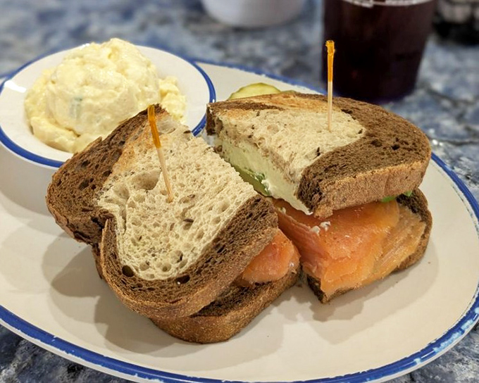 A salmon sandwich that brings the ocean to your plate, paired with grits so creamy they could make a Southerner weep with joy.