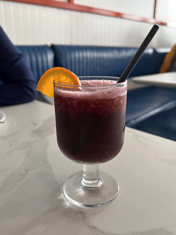 Their sangria arrives like a jewel-toned promise of good times ahead, garnished with orange and served in a glass that says, "Stay awhile."