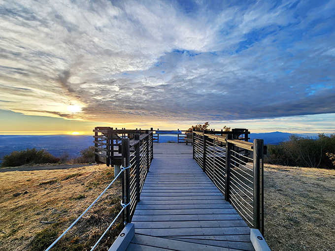 The viewing platform where "just five more minutes" turns into an hour of silent awe. Layers of mountains fade into blue infinity.
