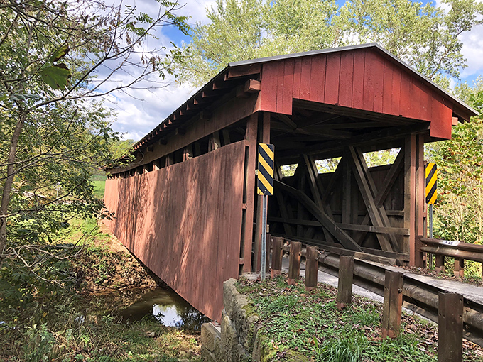 Winter's chill reveals the bridge's steadfast character, its reflection in the creek below doubling the visual delight for lucky passersby.