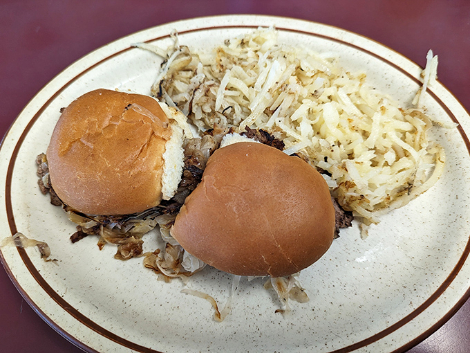 Two humble sliders alongside crispy hash browns—a plate that whispers "comfort" louder than any fancy restaurant could ever shout.