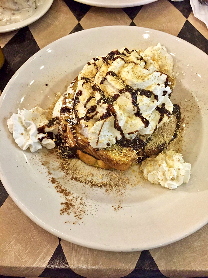 Dessert disguised as breakfast? This s'mores French toast with whipped cream mountains and chocolate drizzle makes morning indulgence an art form.