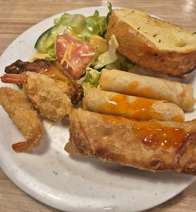 Crispy spring rolls and golden-fried shrimp share real estate with a side salad that's clearly just there as a formality.