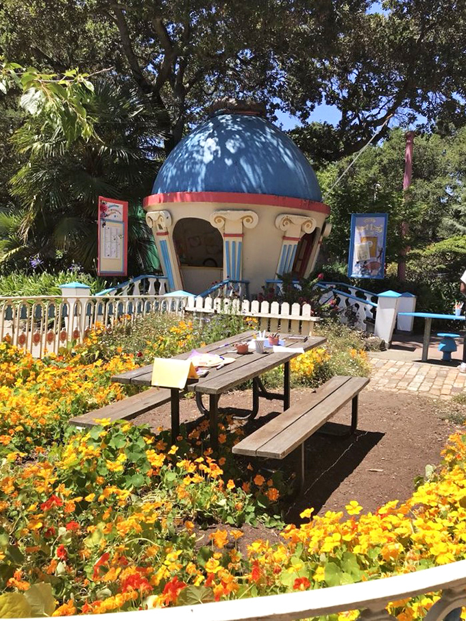 Vibrant flowers surround a picnic area where families can refuel between adventures. Even enchanted lands require snack breaks.