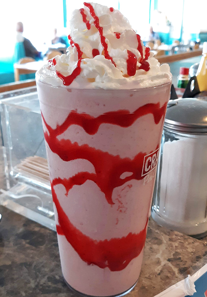 This strawberry shake topped with whipped cream and sauce is basically a celebration in a glass.