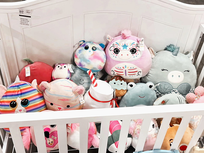 Plush creatures huddle together in their white crib, a soft menagerie of unicorns and ice cream cones with eyes pleading "take me home."