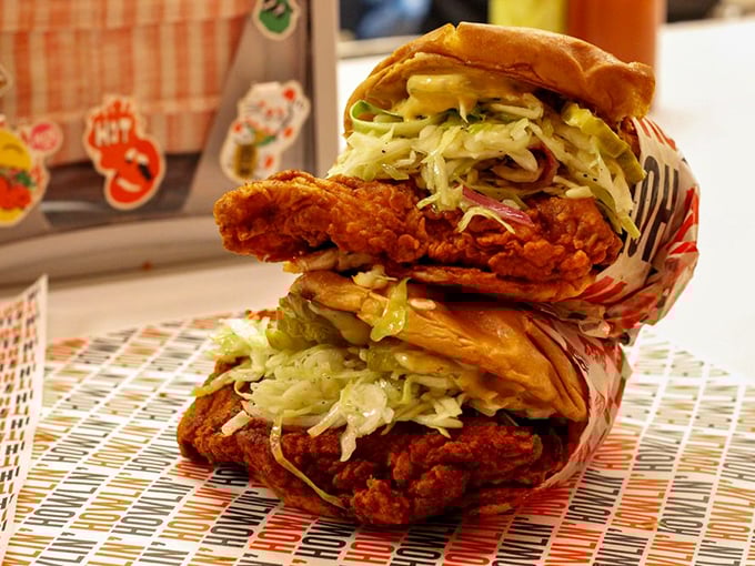 Architecture of deliciousness: layers of crispy chicken, fresh slaw, and pickles create the perfect bite ratio in this towering sandwich masterpiece.