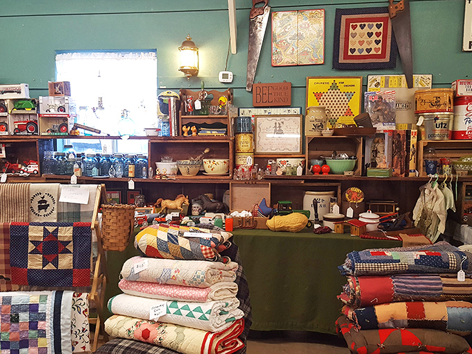 Quilts stacked like colorful chapters of American craftsmanship, surrounded by vintage board games and country collectibles that spark nostalgia.