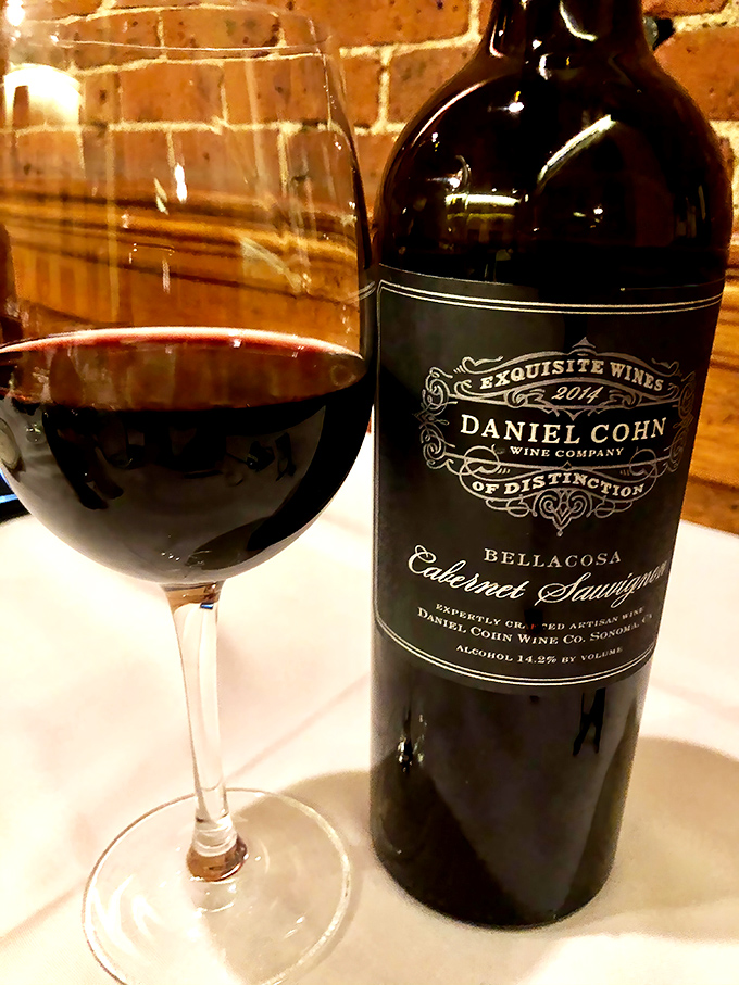 A robust Cabernet against crisp white linens and brick walls&mdash;because great steak demands a worthy liquid companion.