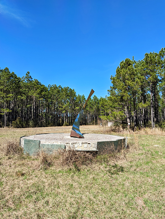 Modern art meets ancient mystery with this sleek sculpture rising from a concrete platform. Like a sundial designed by someone who prefers to keep time mysterious.