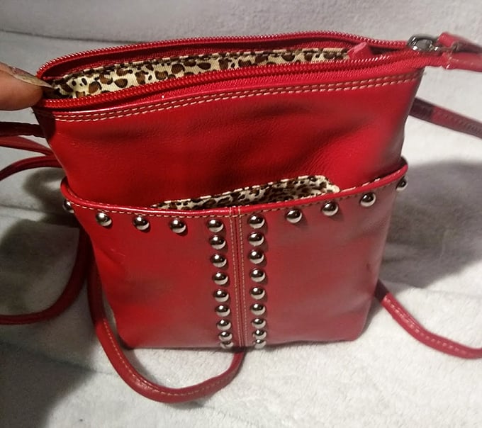 This studded red handbag isn't just an accessory; it's a statement piece with leopard-print lining that whispers, "I have secrets to tell."