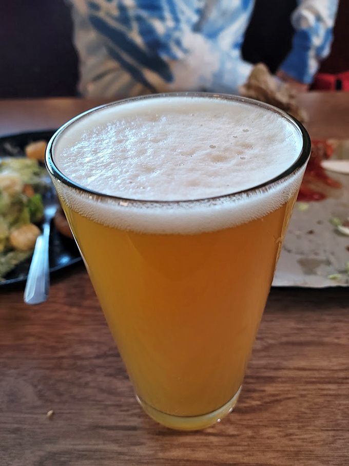 A perfectly poured pint with that ideal foam crown&mdash;because every royal burger deserves a worthy beverage companion.