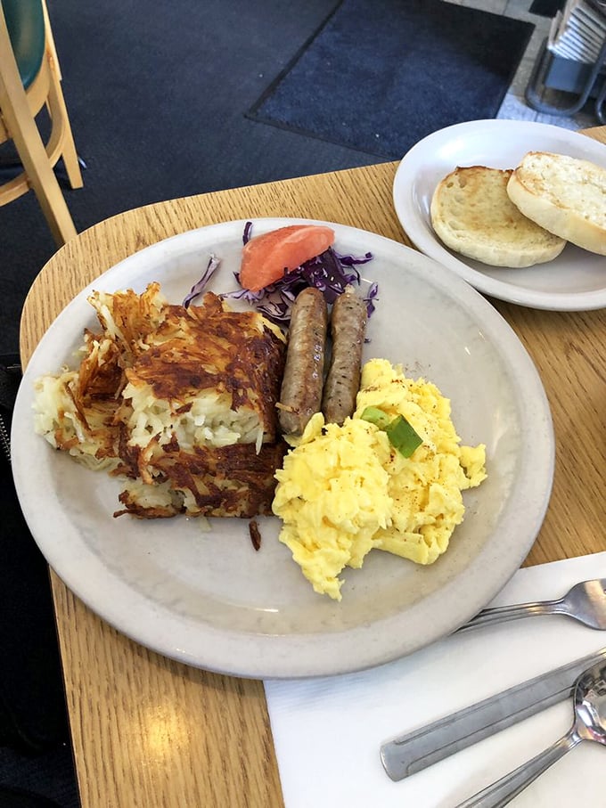 Breakfast, deconstructed: fluffy scrambled eggs, sausage links with perfect snap, and hash browns that crackle with each forkful. English muffins stand by for yolk-sopping duty.