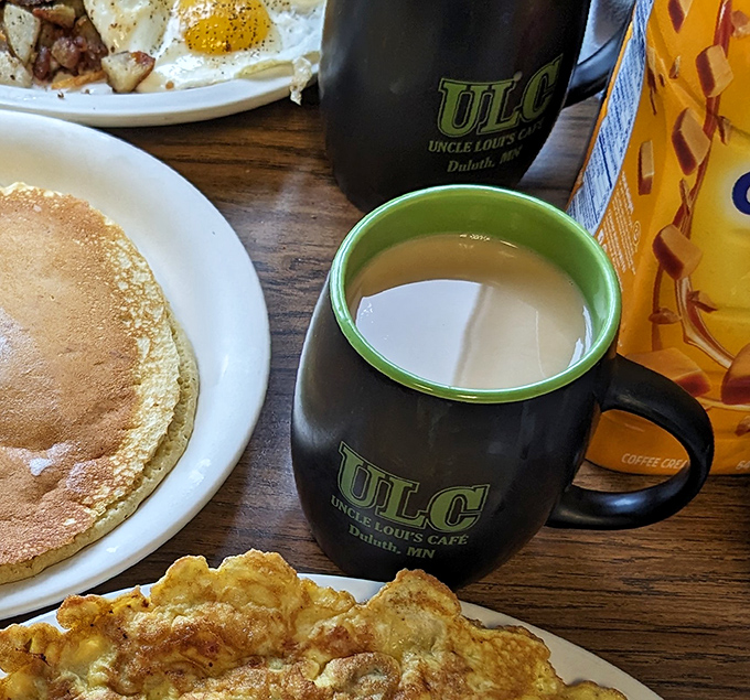 The perfect diner trifecta: a steaming mug of coffee, golden pancakes, and a fluffy omelet&mdash;the breakfast equivalent of winning the lottery.