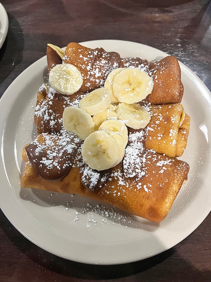 These crepes aren't just folded—they're lovingly embracing their banana and chocolate filling like they've found their soulmate on a plate.