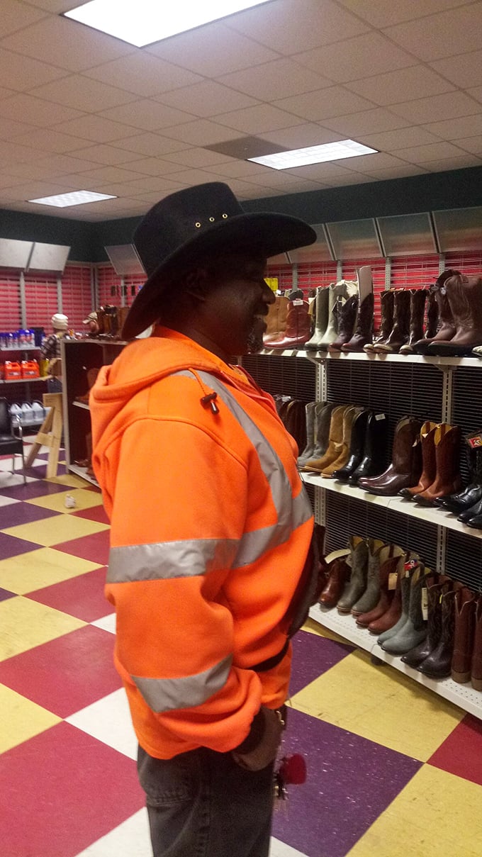 A shopper contemplates cowboy boots - in a flea market, you don't just find items, you find new personas to try on.