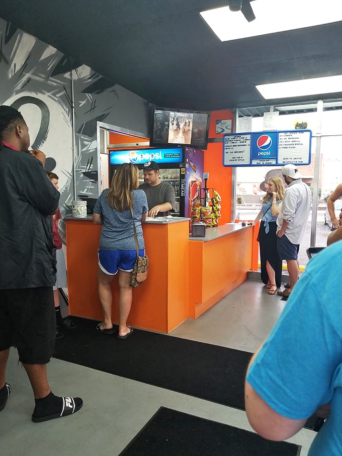 The line forms quickly at Pizza Cat's vibrant orange counter, where locals know that good things come to those who wait.