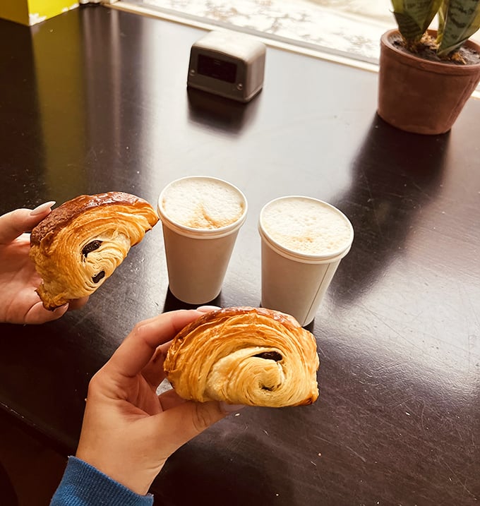 The perfect morning trifecta: chocolate croissants and coffee, proving that sometimes the simplest pleasures deliver the most profound happiness.