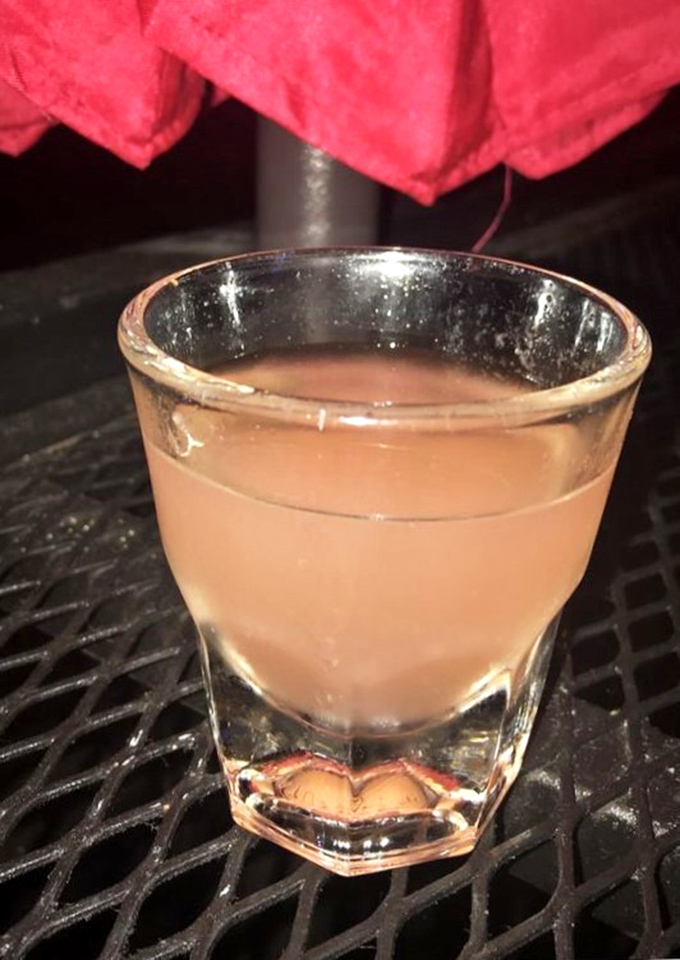 A perfectly poured cocktail waiting to wash down that slice—because adulting sometimes means pairing your pizza with something stronger than soda.