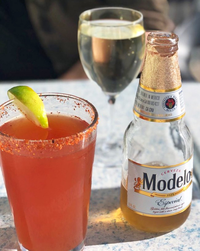 Nothing says "vacation mode activated" quite like a spicy red cocktail with a salt rim and a cold Modelo standing by. Coastal drinking at its finest.