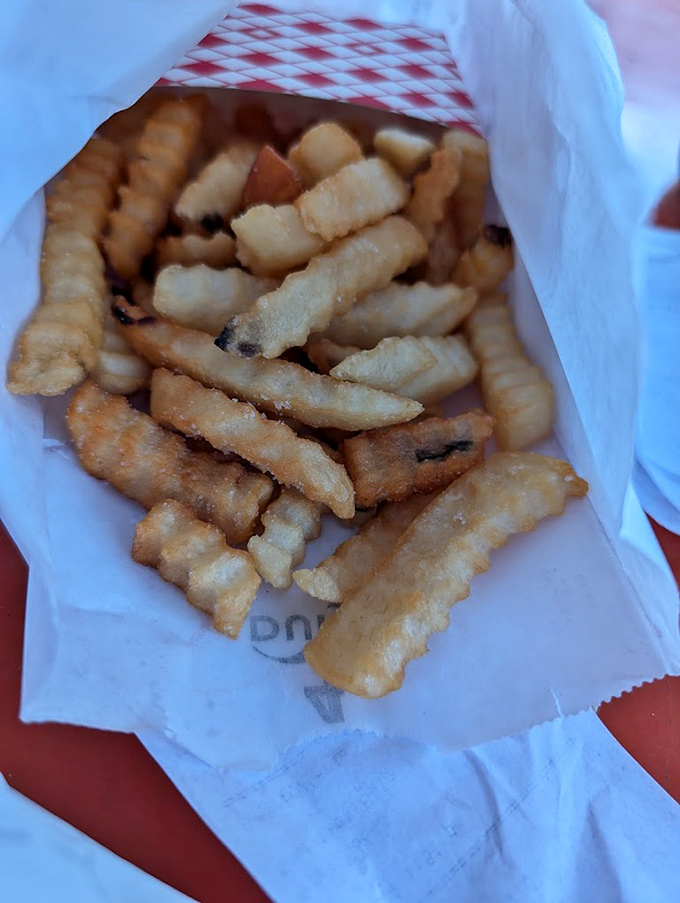 Crinkle-cut fries nestled in paper&mdash;simple, unpretentious, and exactly what you want alongside sandwich perfection.