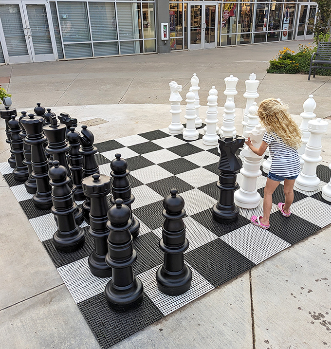 Giant chess pieces transform ordinary shopping breaks into strategic battles where even pawns stand taller than the young players.